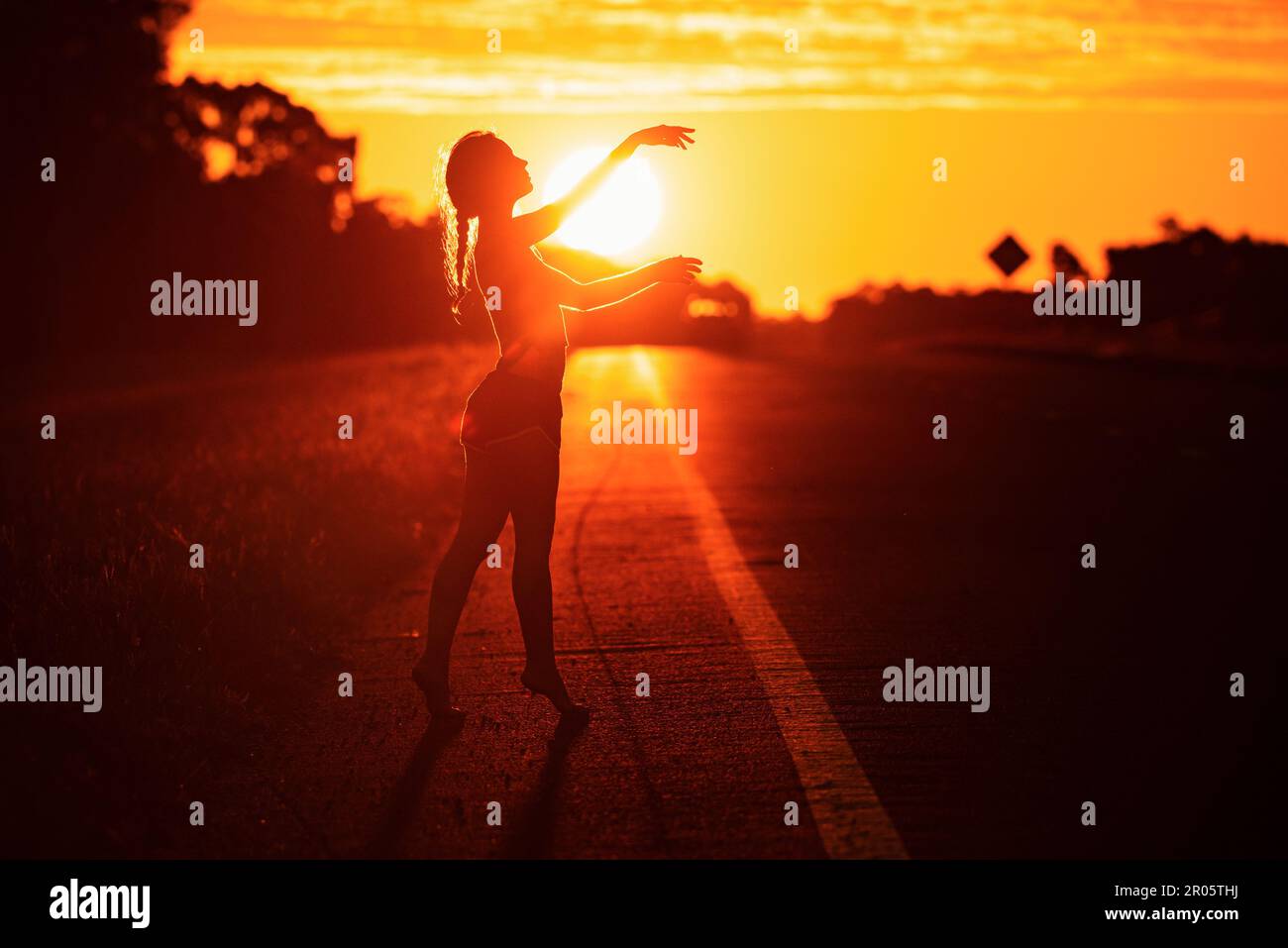 Young woman dancing in summer sunset sky outdoor. People freedom style ...