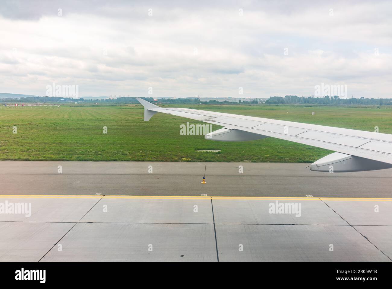 View of airplane wing, blue skies and green land during landing ...