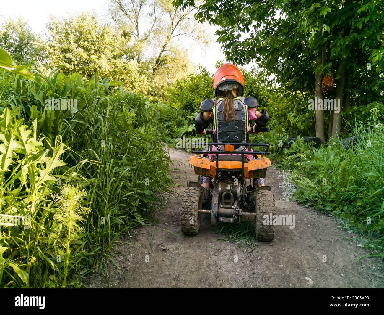 A child rides a quad bike through the mud. ATV rider rides Stock Photo ...