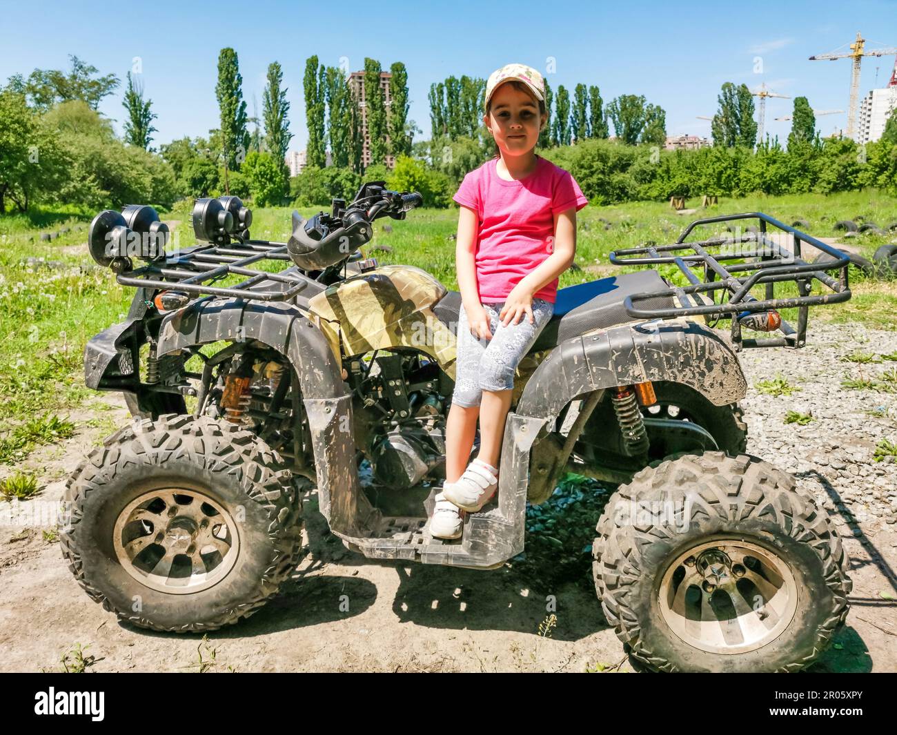 A child rides a quad bike through the mud. ATV rider rides Stock Photo ...
