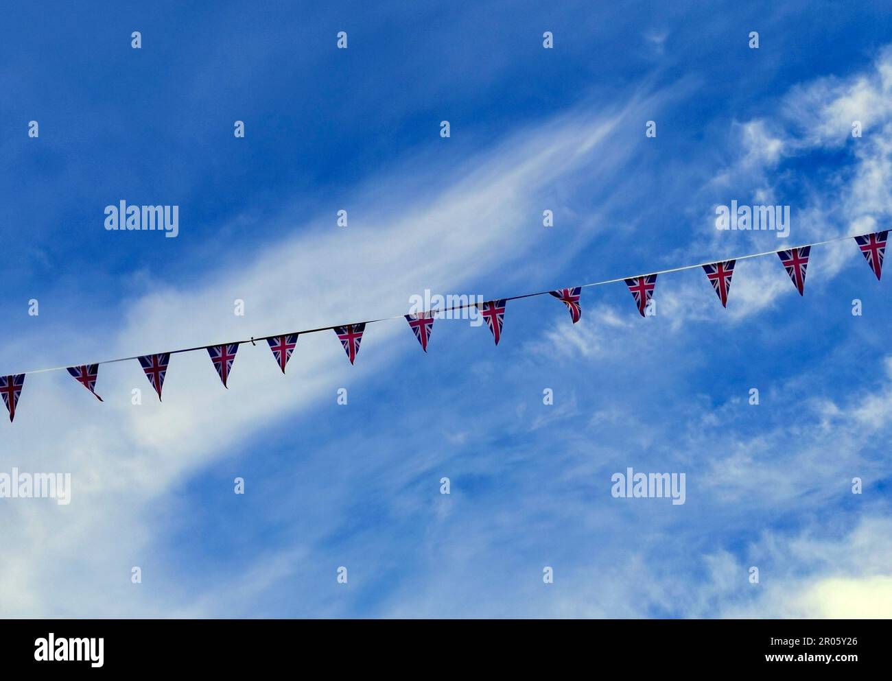 Coronation Union Jack bunting across deep blue sky with copy space ...