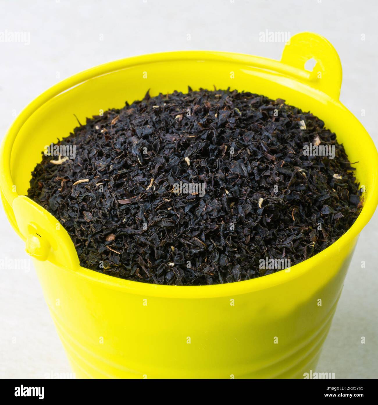 Chinese black tea in a yellow palstic mini bucket Stock Photo - Alamy