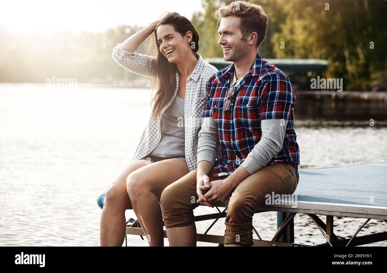Taking a timeout, together. a happy young couple sitting on a pier ...