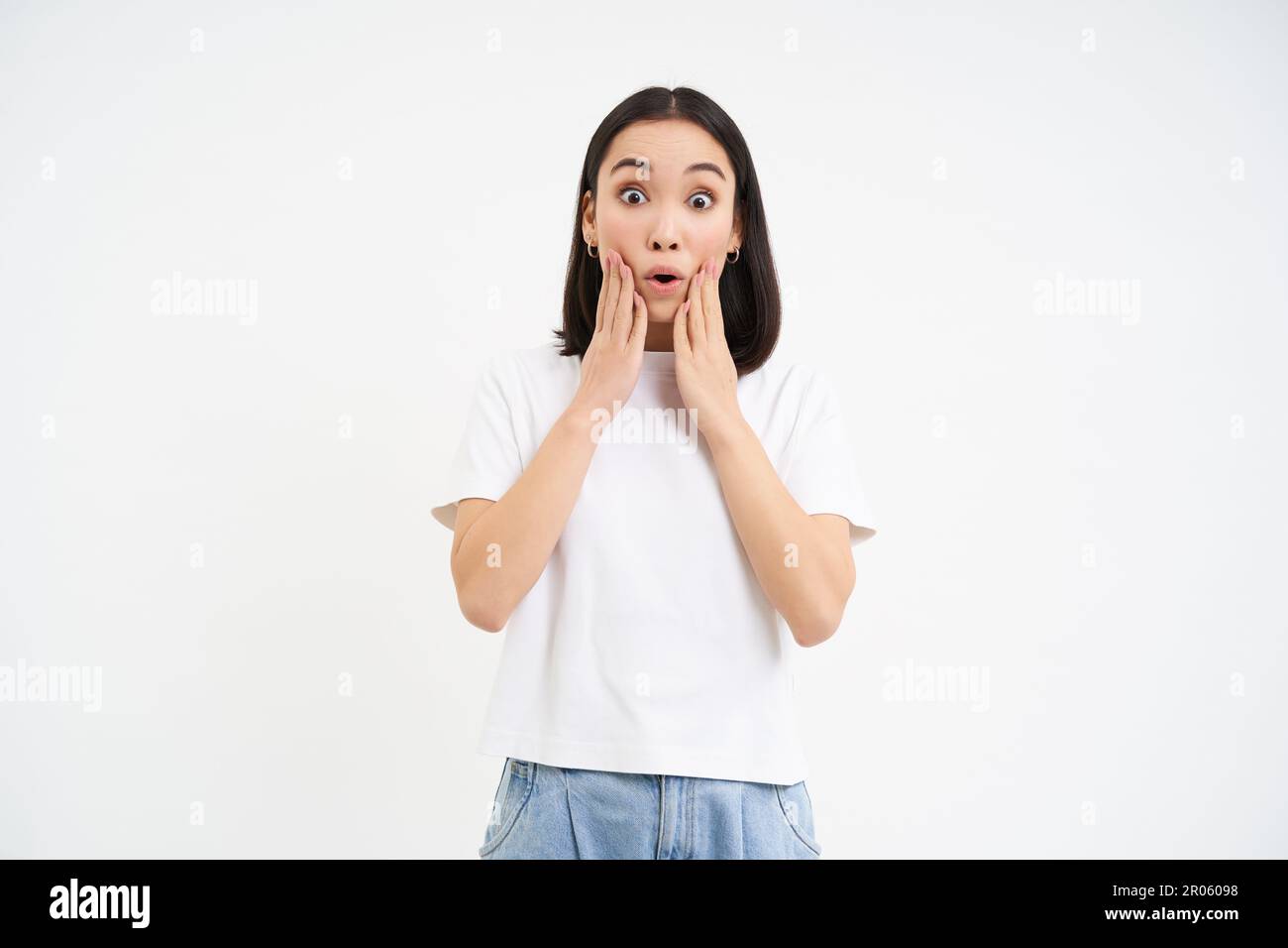 Girl with surprised face, gasps and stares at camera with shocked ...