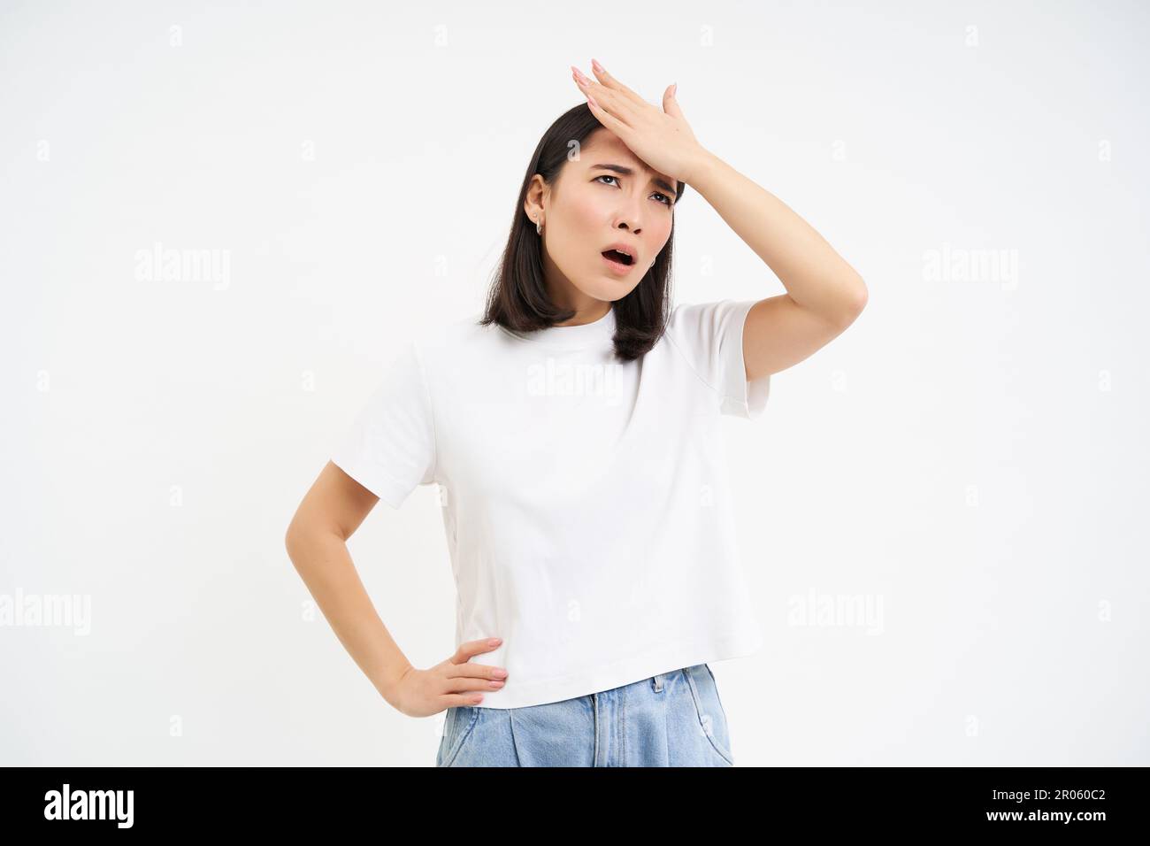 Troubled young woman, slaps her forehead, look bothered, forgot ...