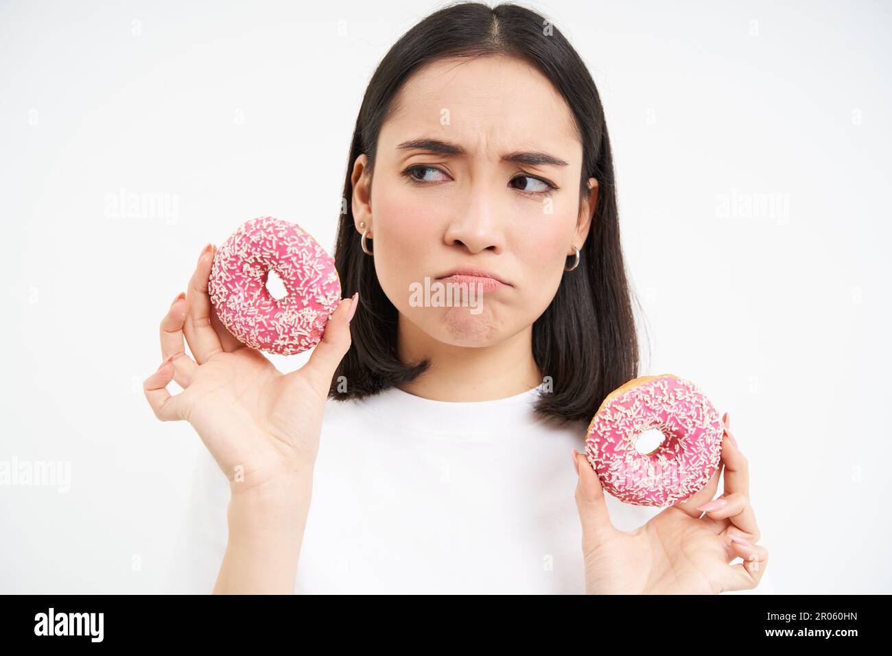 Close up portrait of sad asian woman, upset being on diet, showing two ...