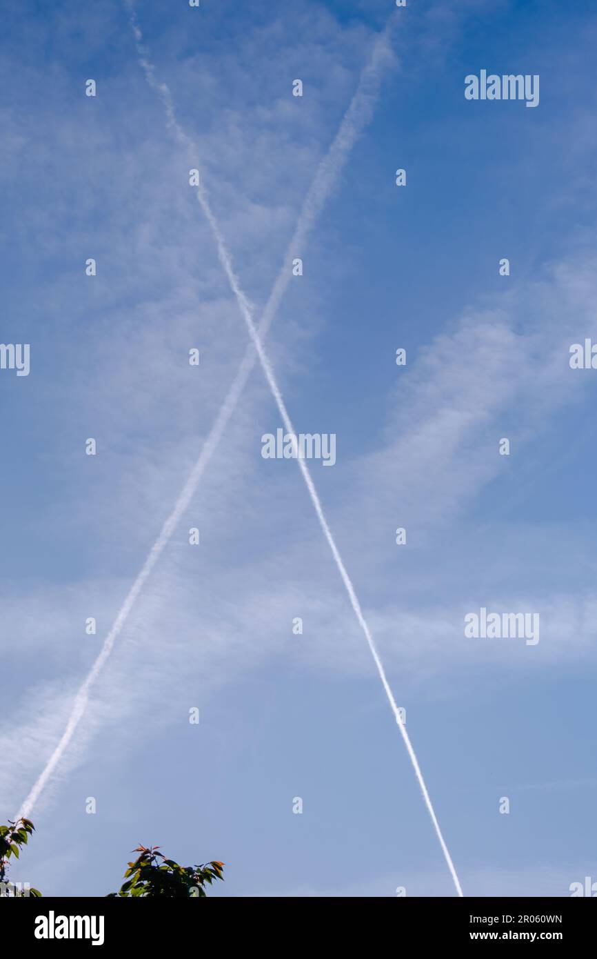 Blue sky with crossing condensation trails hi-res stock photography and ...