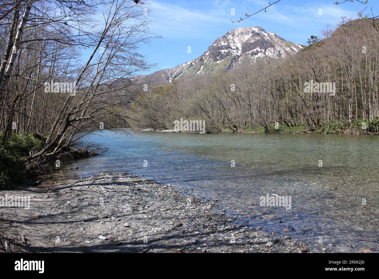 The clear Azusa River and snow-capped Mount Yakedake viewed from ...