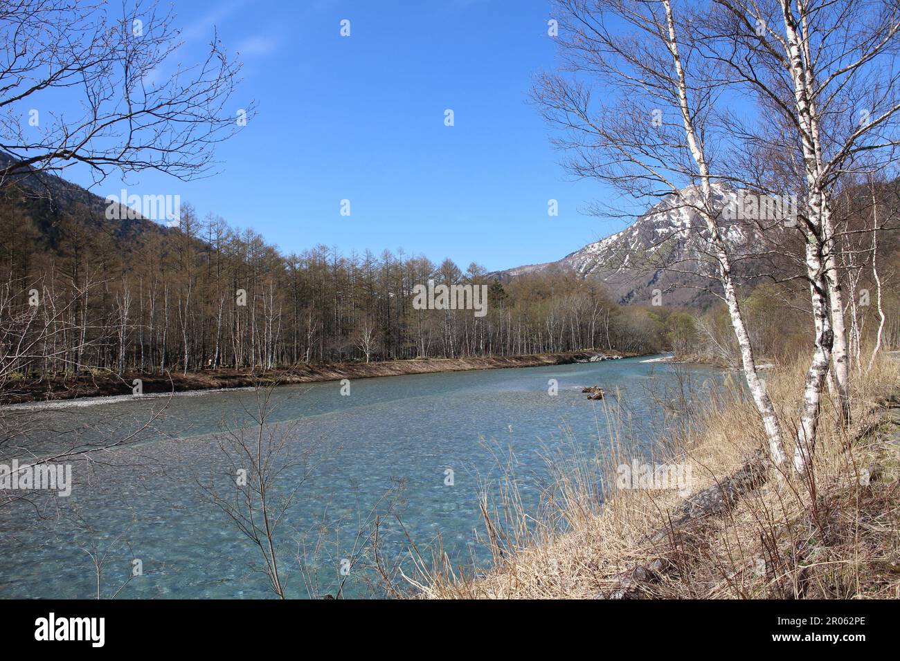 The clear Azusa River and snow-capped Mount Yakedake viewed from ...