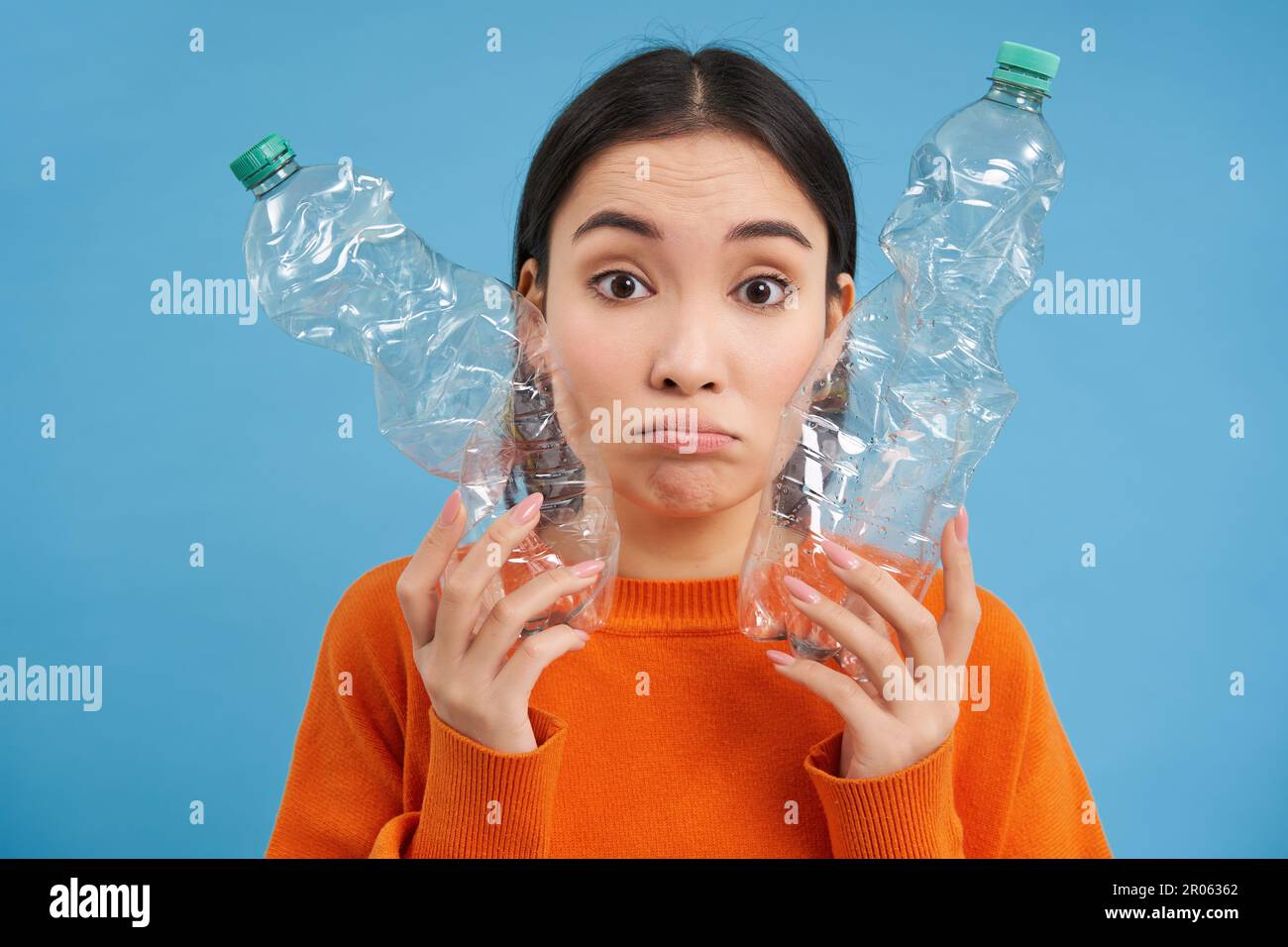 Portrait of sad asian woman with plastic bottles, upset by lack of ...