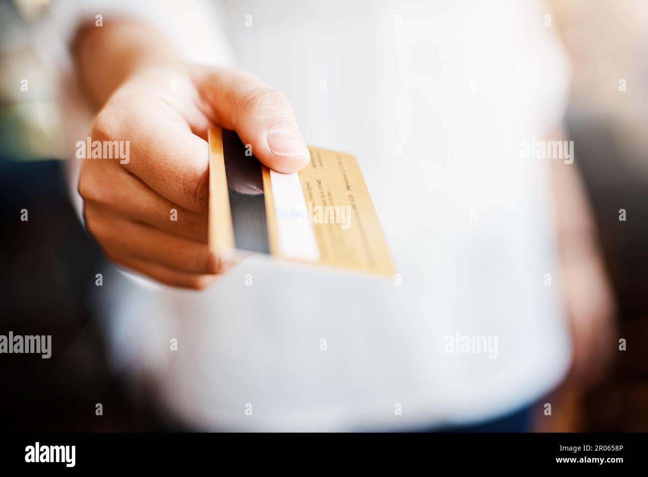 Just use my card. an unrecognizable woman holding up her bank card ...