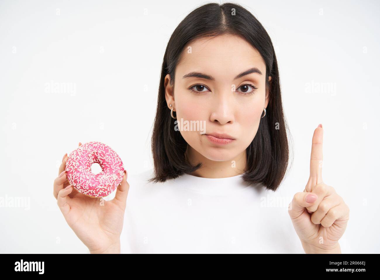 No sweets. Serious young woman on diet, showing stop gesture and glazed ...