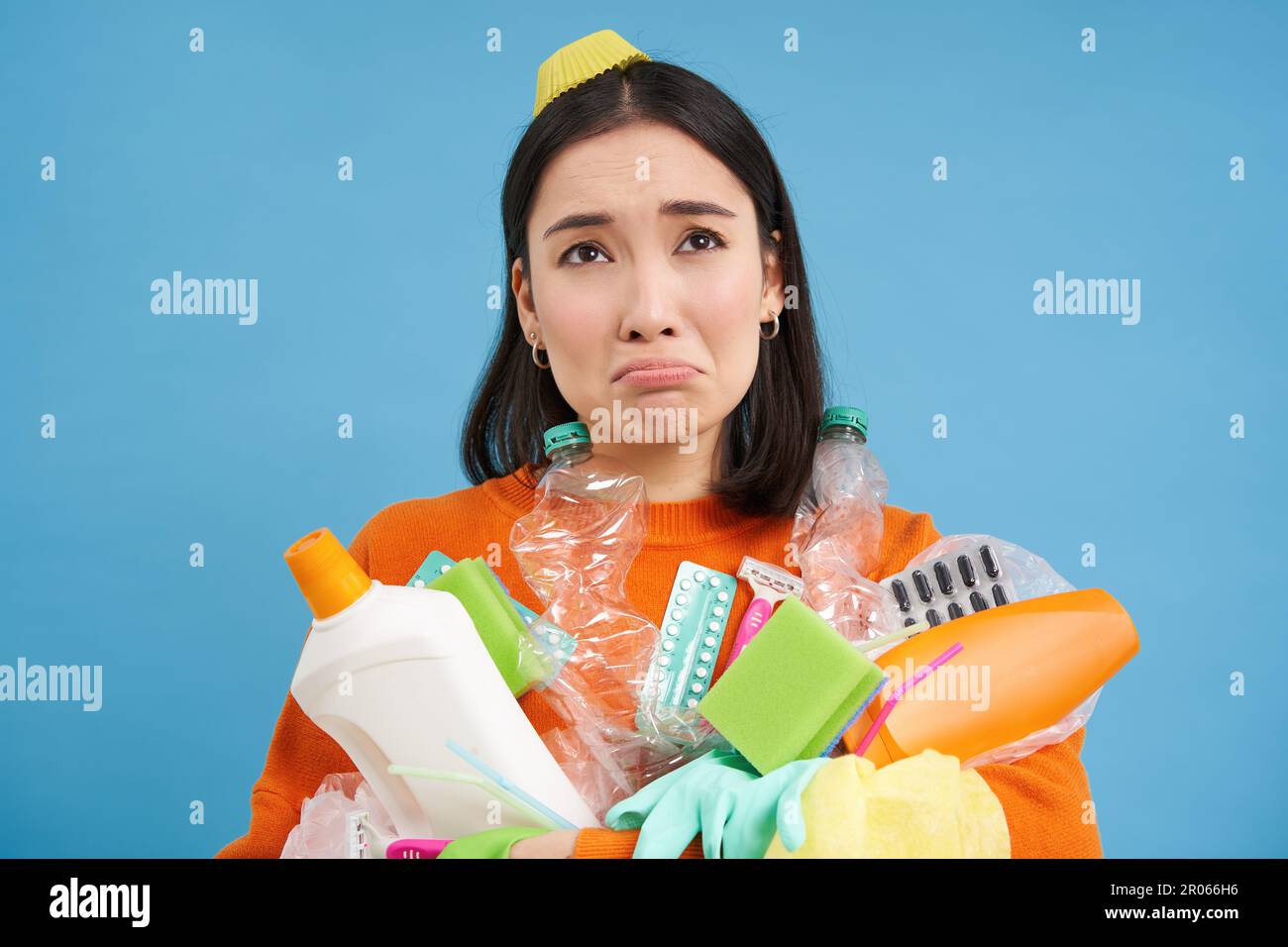Portrait of crying sad girl with plastic trash, collects recycling ...