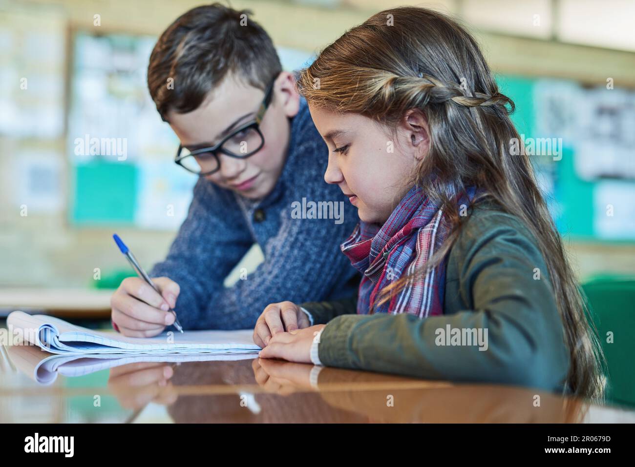 Getting some help from a fellow classmate. two elementary school kids ...