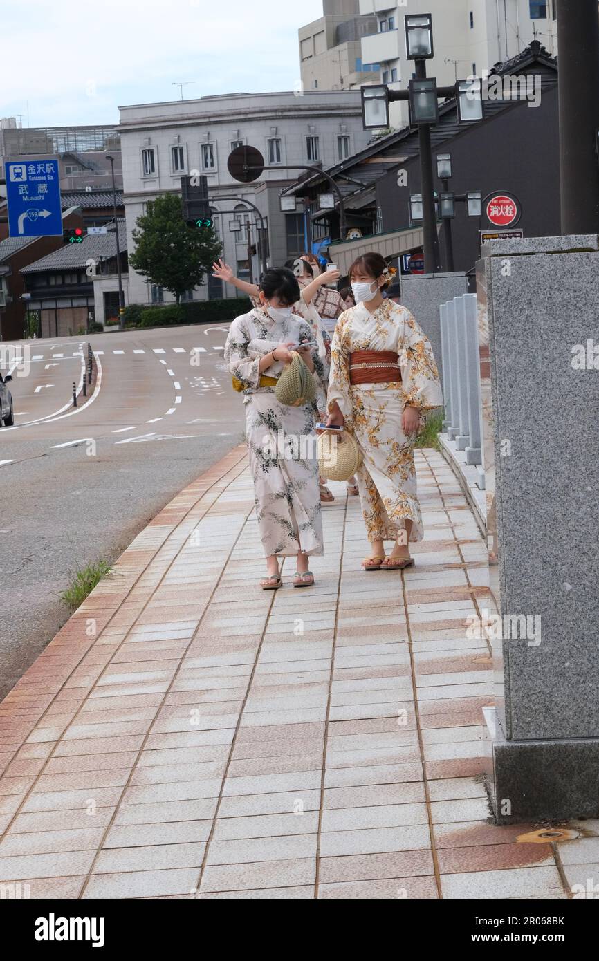 A group of young girls wearing masks and summer kimonos called yukata ...
