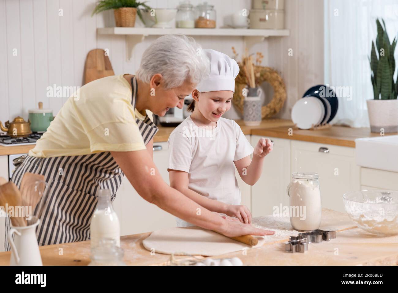 Happy family in kitchen. Grandmother and granddaughter child cook in ...