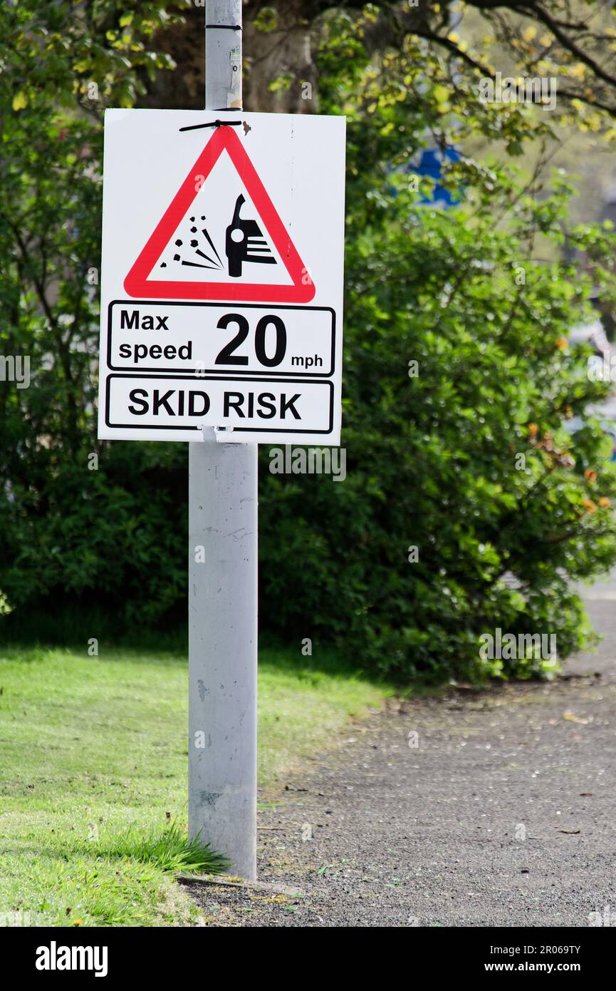 Skid risk road speed limit safety sign Stock Photo - Alamy