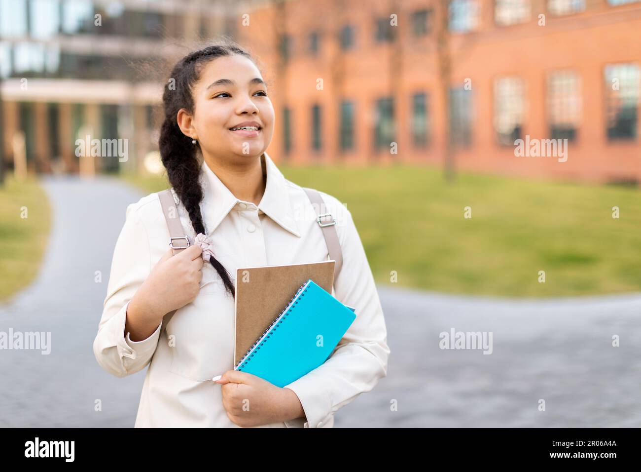 Portrait of positive student lady standing outdoors, teen with ...