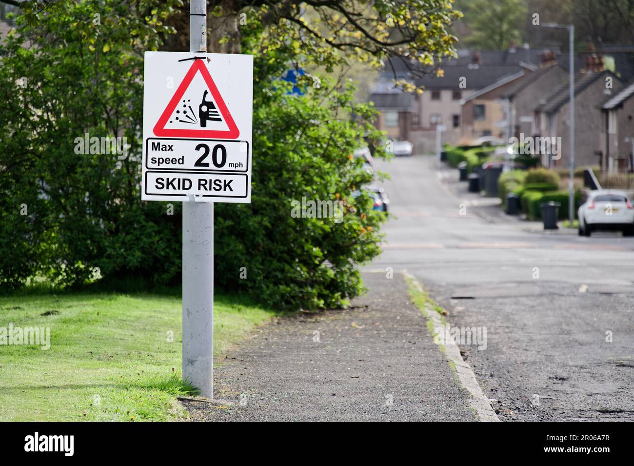 Skid risk road speed limit safety sign Stock Photo - Alamy