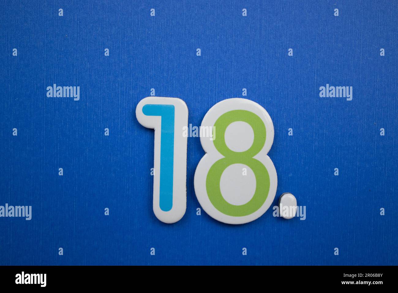 The number 18, placed on a blue background, photographed from above, in light blue and green ...