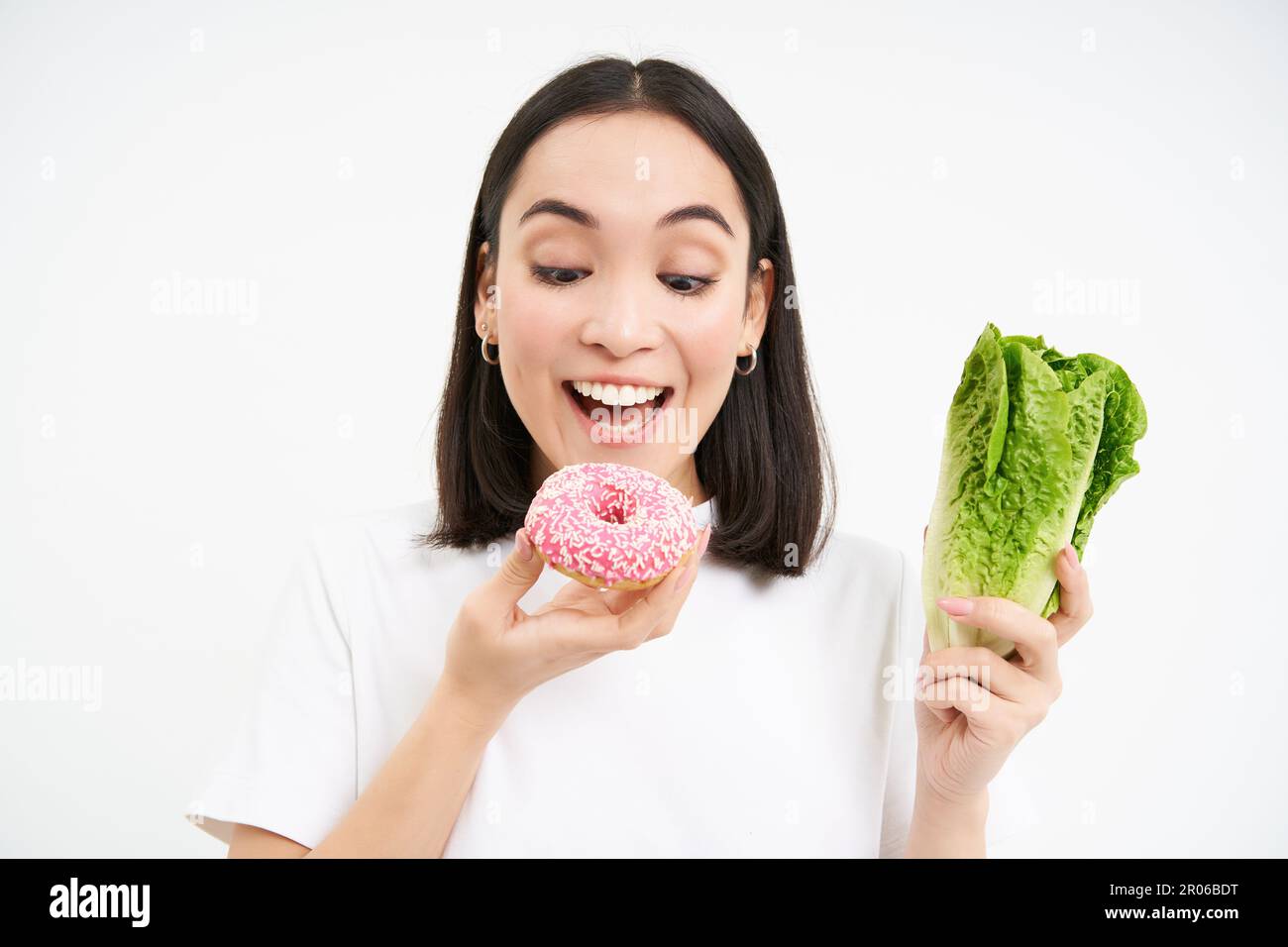 Healthy clean detox eating concept. Vegetarian, vegan, raw concept. Happy girl takes bite of ...