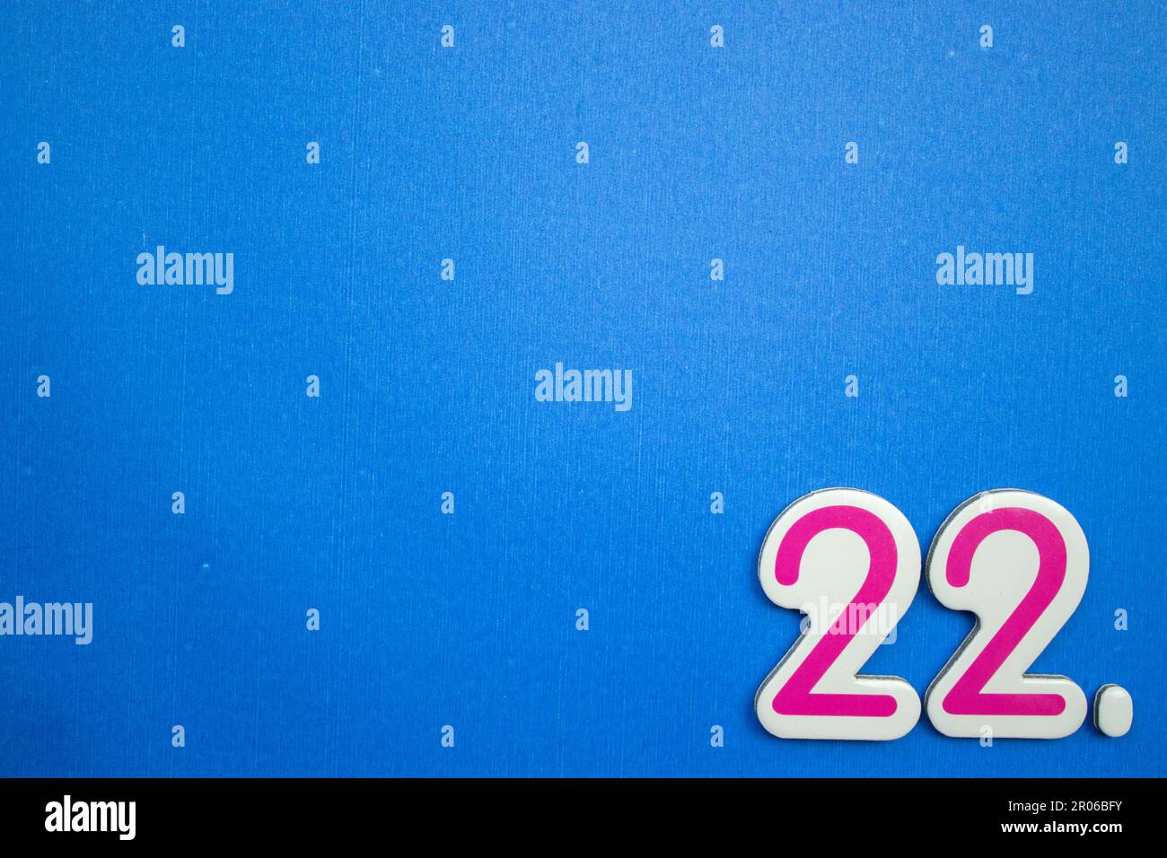 The number 22, placed on the edge of a blue background, photographed ...