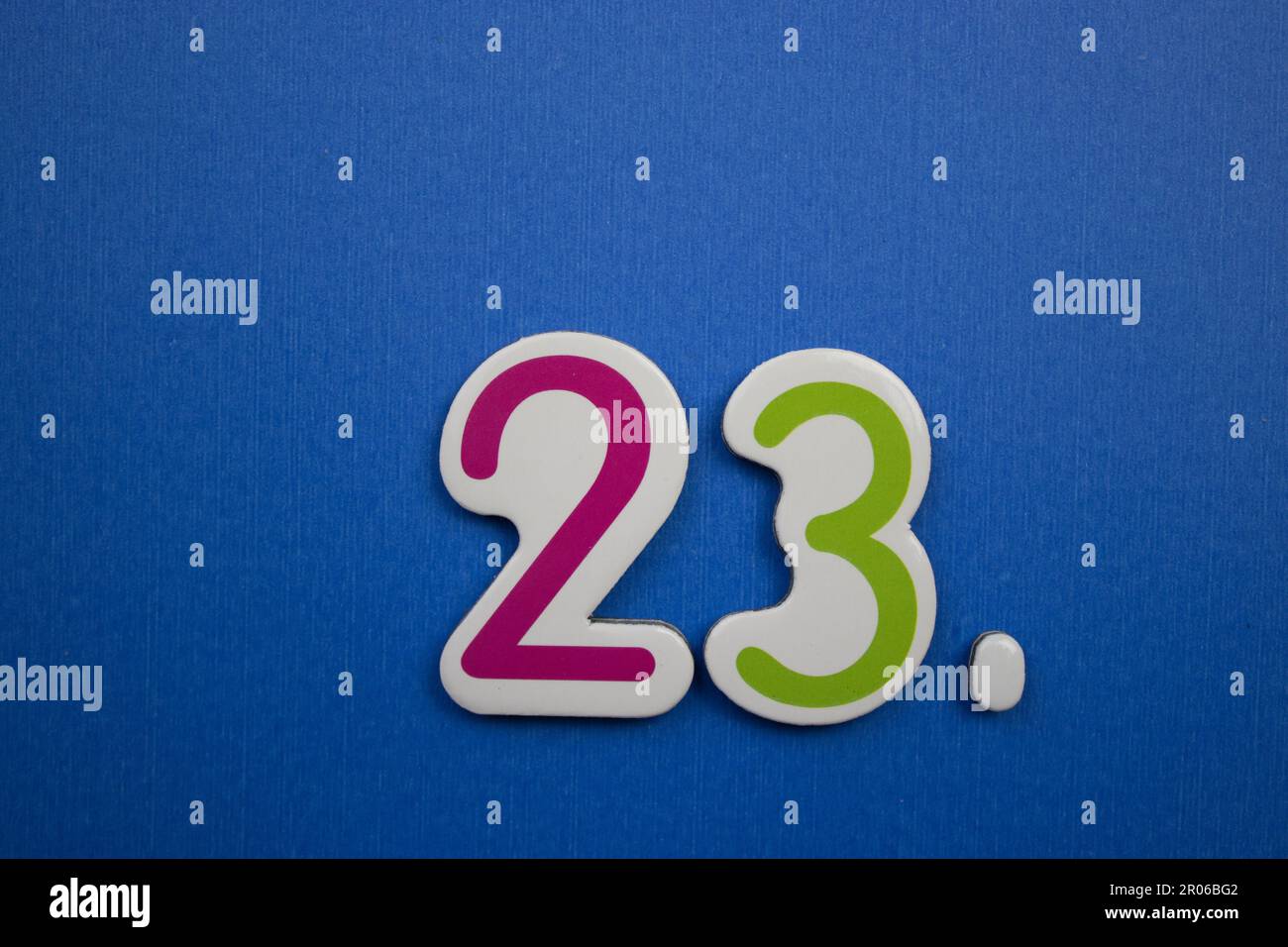 The number 23, placed on a blue background, photographed from above ...