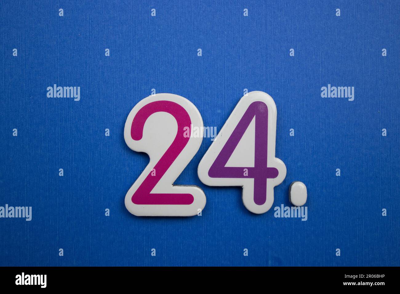 The number 24, placed on a blue background, photographed from above, colored red and purple ...