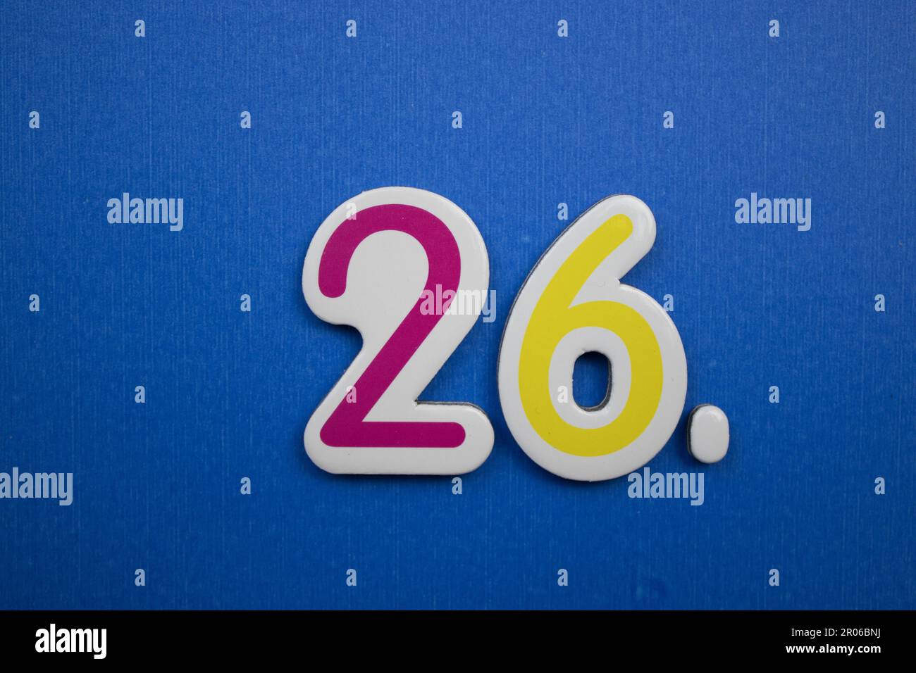 The number 26, placed on a blue background, photographed from above ...