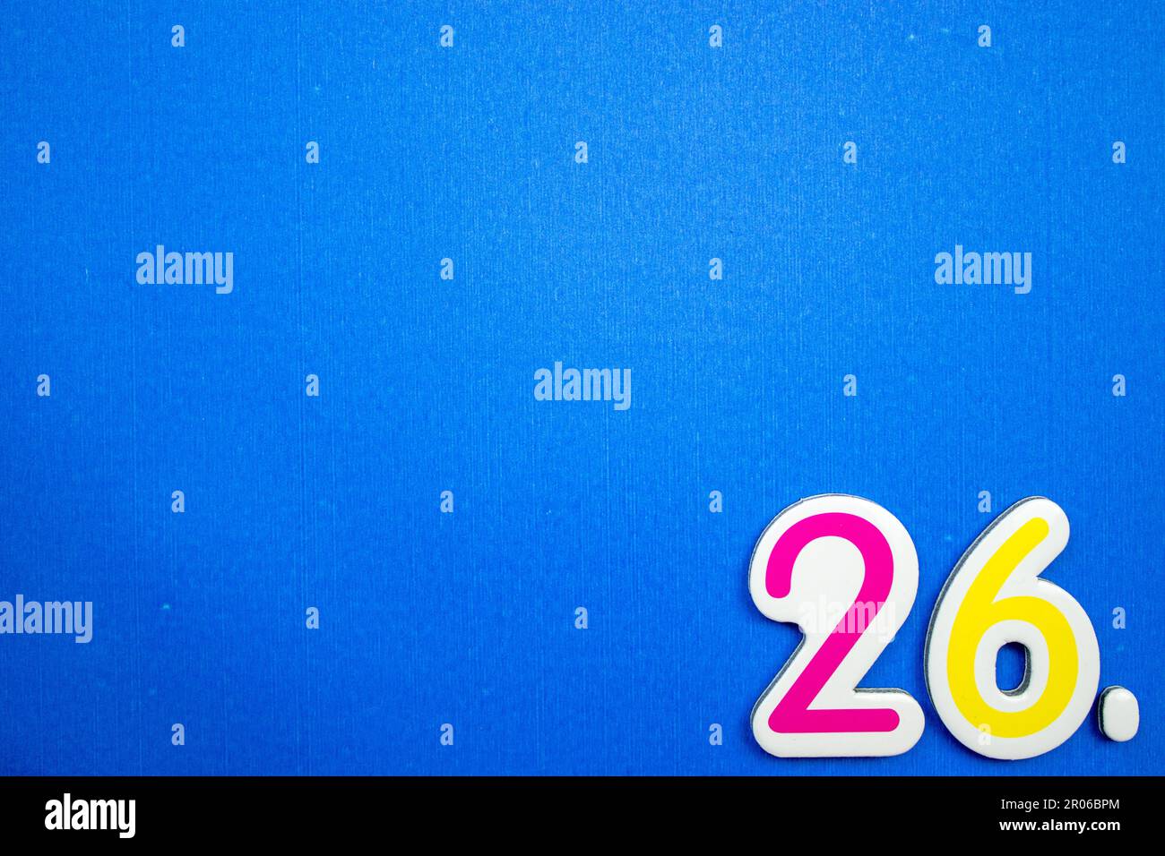 The number 26, placed on the edge of a blue background, photographed ...