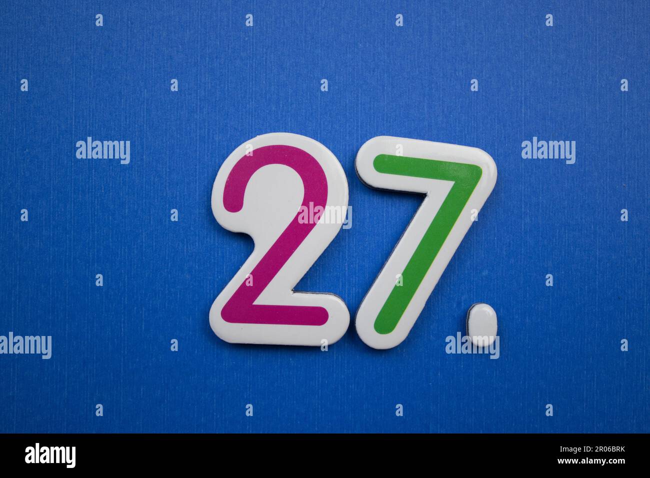 The number 27, placed on a blue background, photographed from above ...