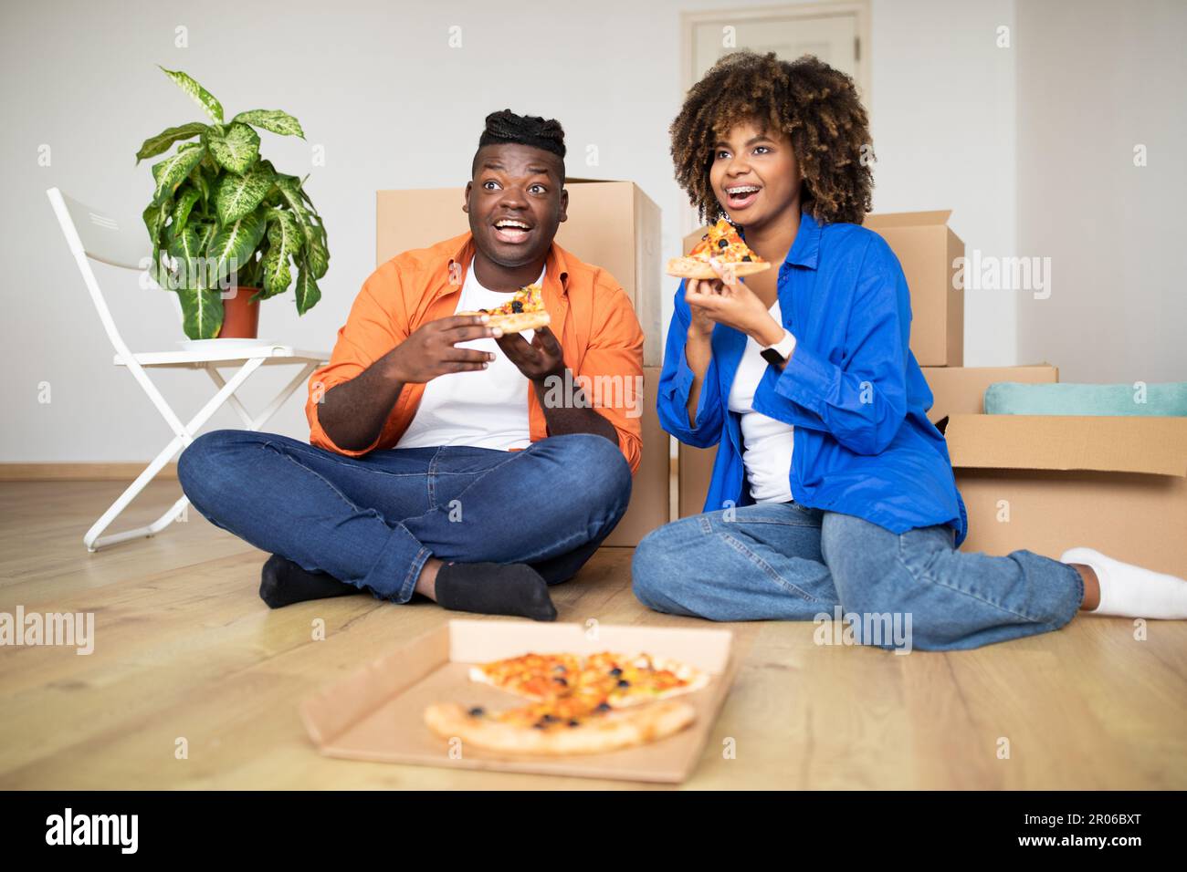 African American Couple Relaxing With Pizza On Moving Day Stock Photo ...