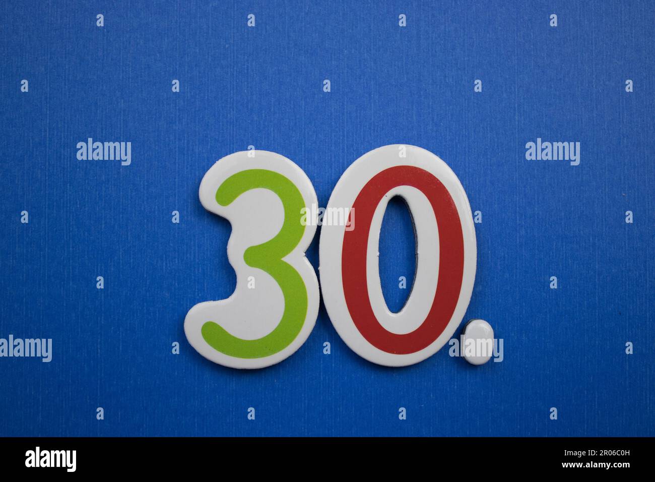 The number 30, placed on a blue background, photographed from above ...