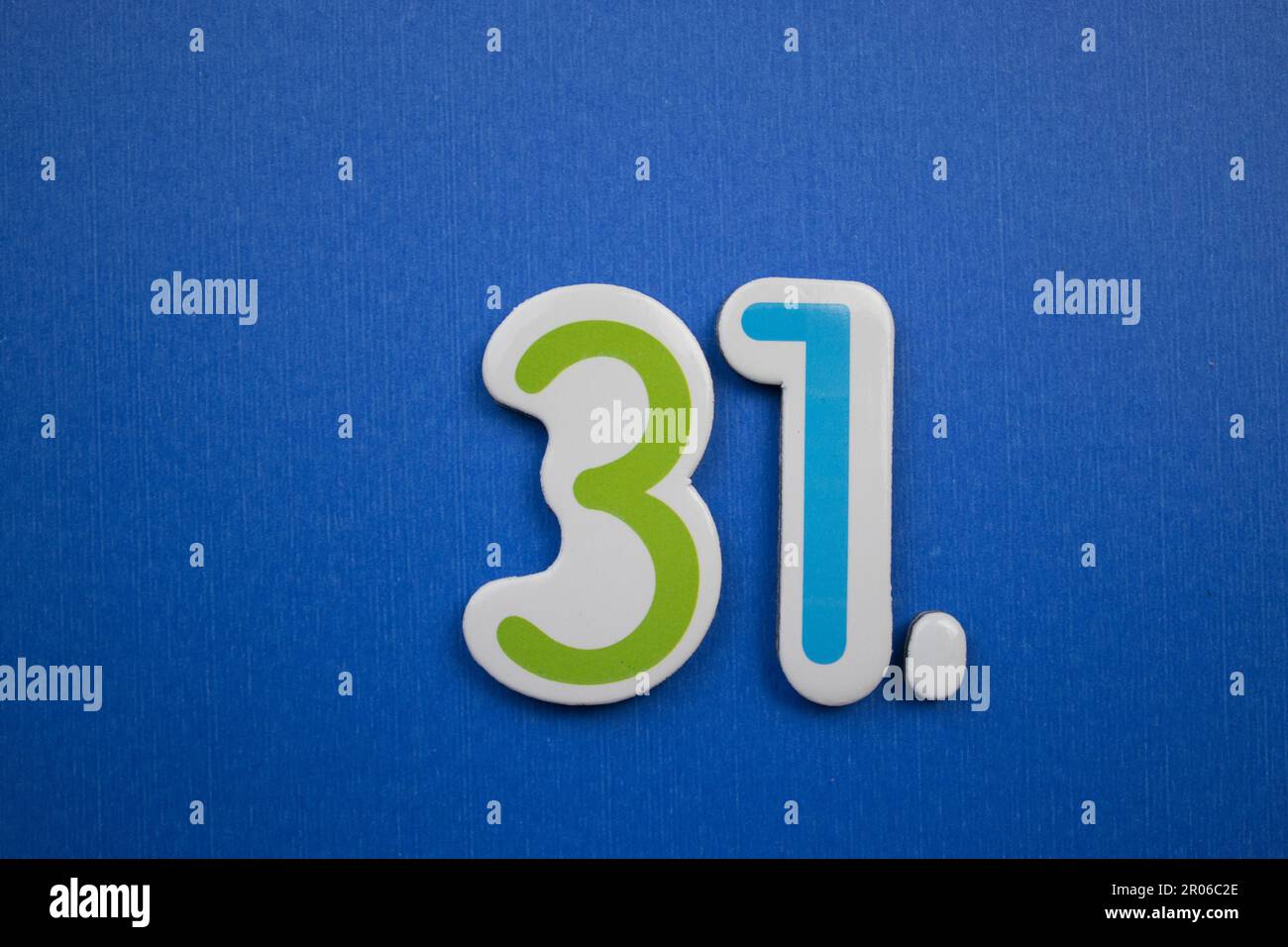 The number 31, placed on a blue background, photographed from above ...