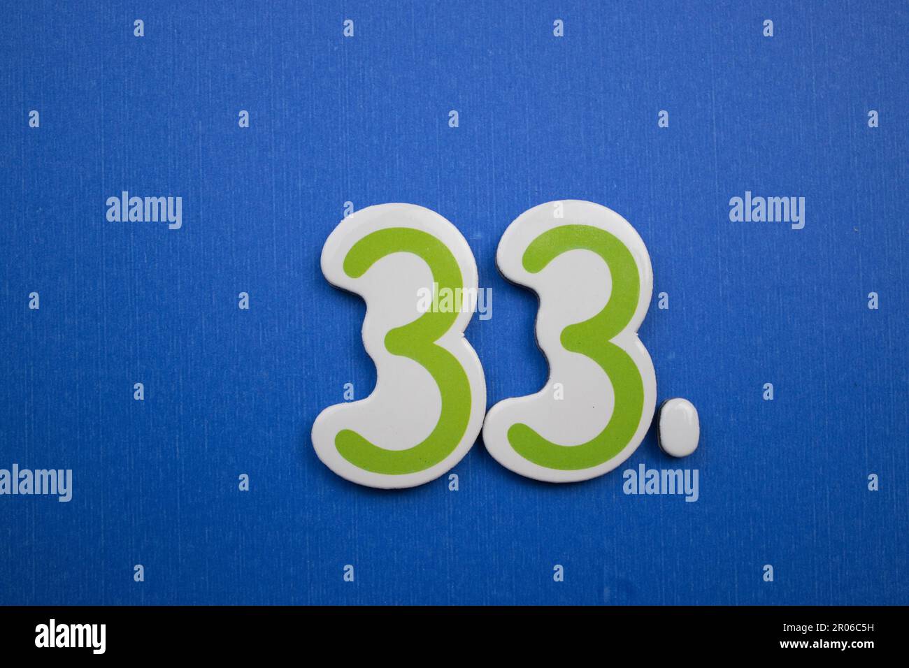 The number 33, placed on a blue background, photographed from above ...