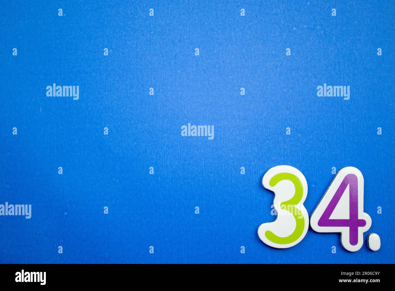 The number 34, green and purple, photographed from above, placed on the ...