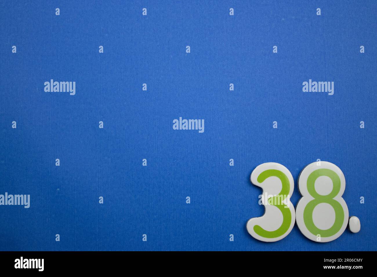 The number 38, placed on the edge of a blue background, photographed ...