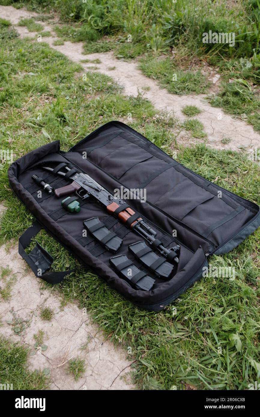 Uncovered gun case with AK-47, magazines, and flashlight lying on the ...