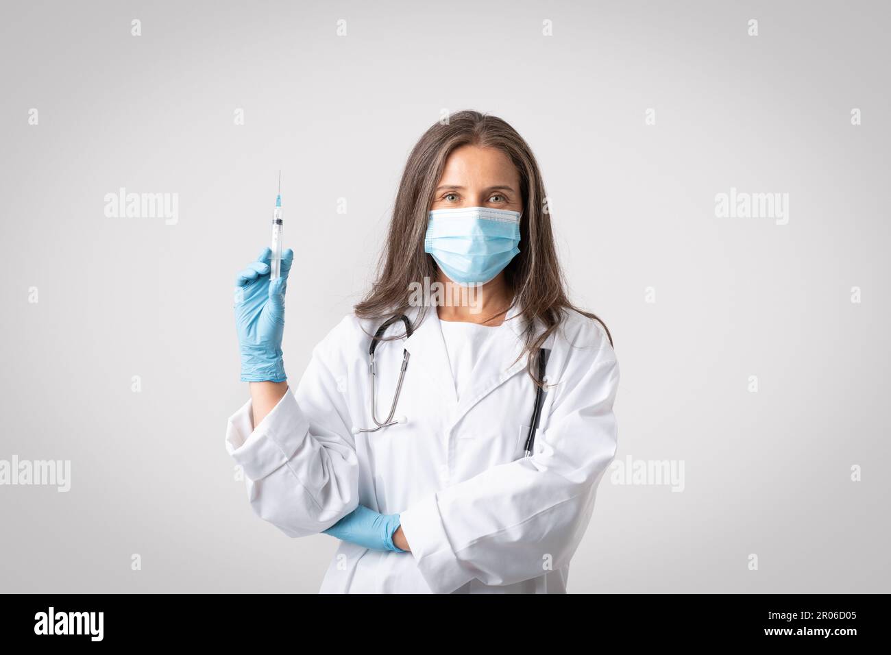 Immunization concept. Senior doctor woman in medical mask holding ...