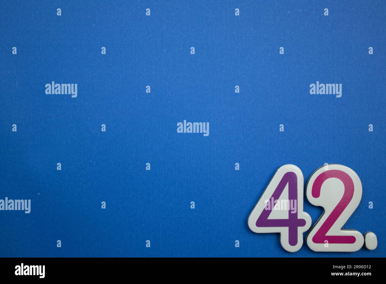 The number 42, placed on the edge of a blue background, photographed ...