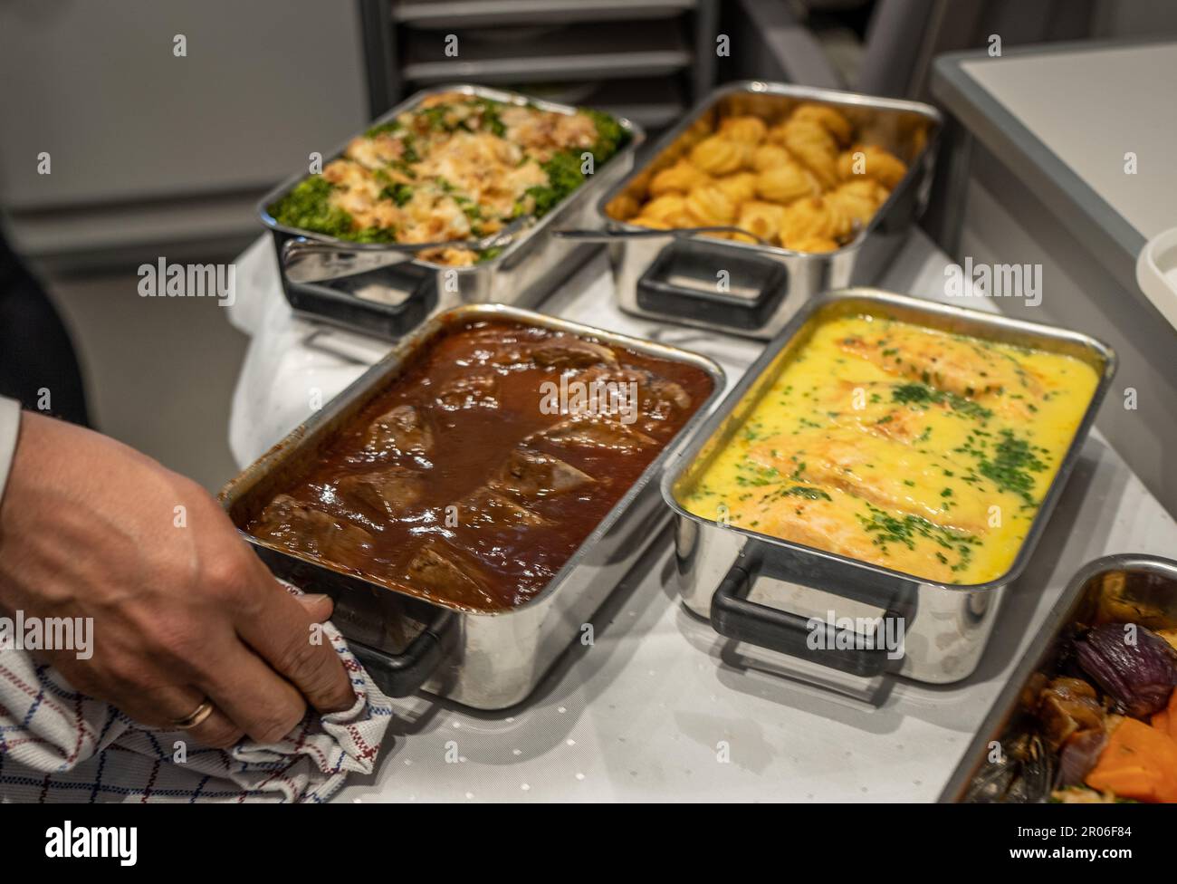 04 May 2023, Brandenburg, Schönefeld: Flight attendants serve food to ...