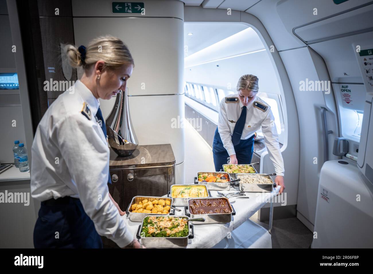 04 May 2023, Brandenburg, Schönefeld: Flight attendants serve food to ...