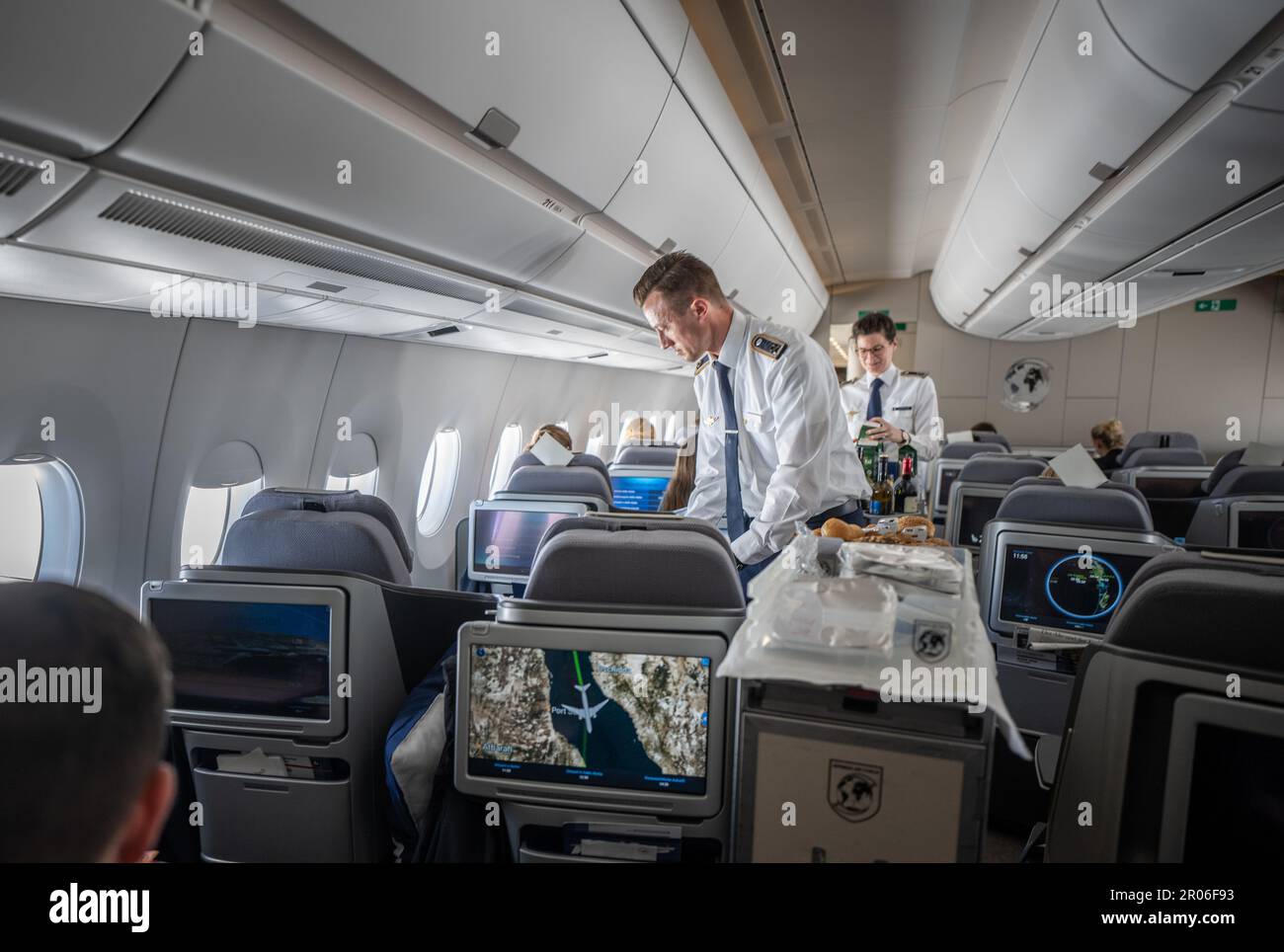 04 May 2023, Brandenburg, Schönefeld: A flight attendant serves lunch ...