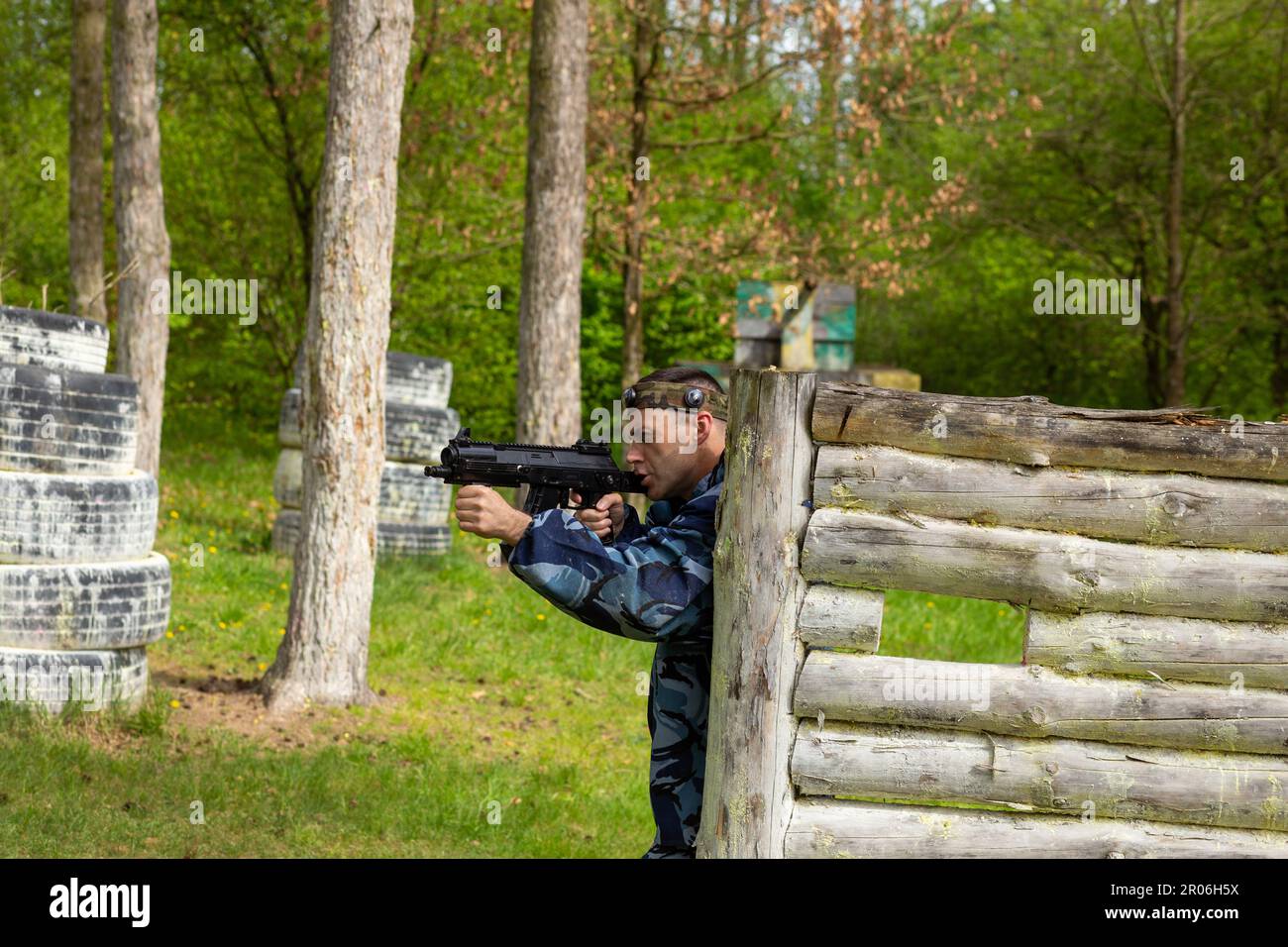 Young man weared in camouflage playing laser tag in special forest ...