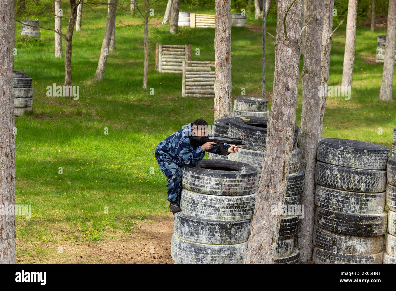 Young man weared in camouflage playing laser tag in special forest ...