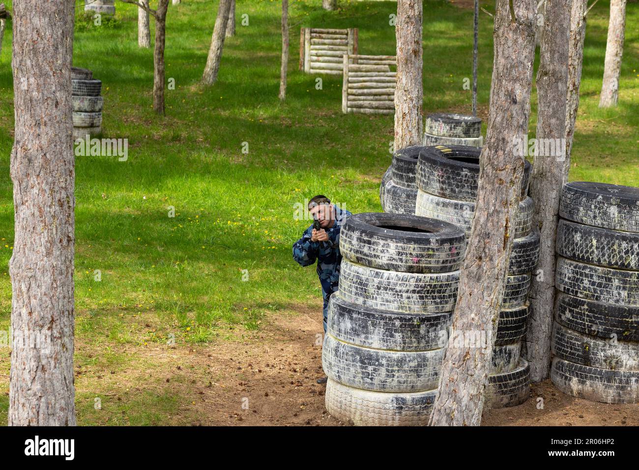 Young man weared in camouflage playing laser tag in special forest ...