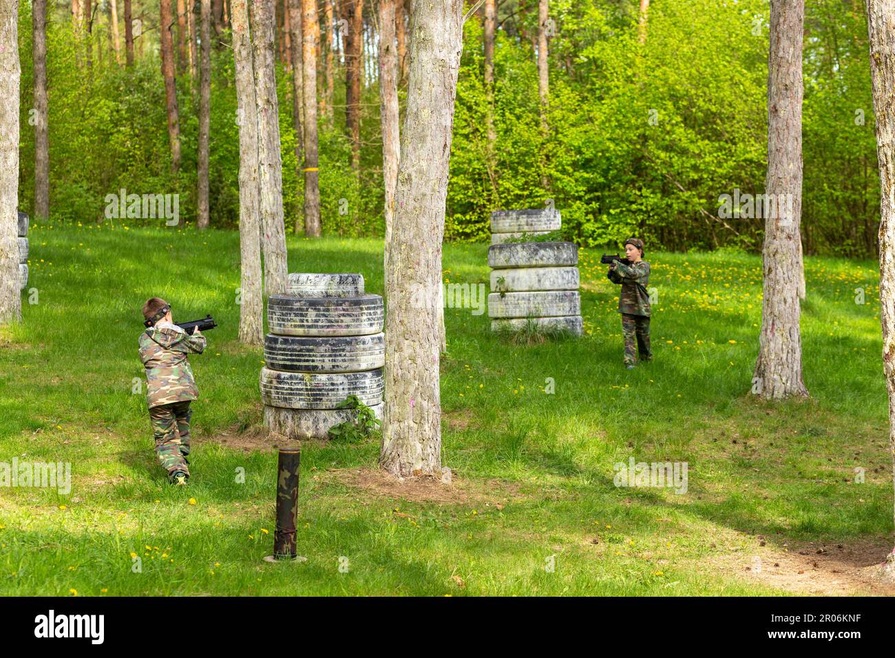 Boy weared in camouflage playing laser tag in special forest playground ...