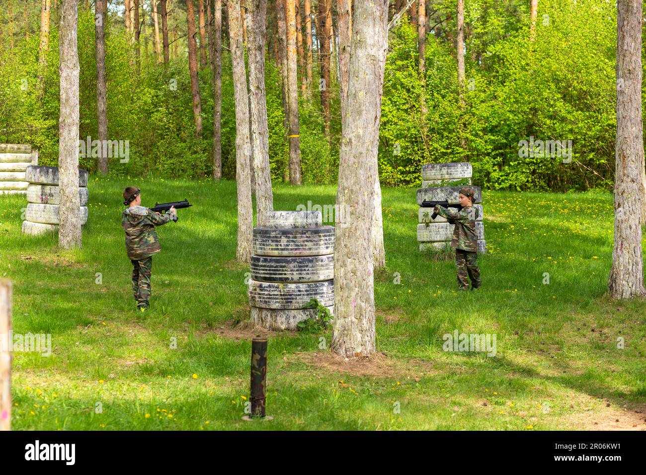 Boy weared in camouflage playing laser tag in special forest playground ...