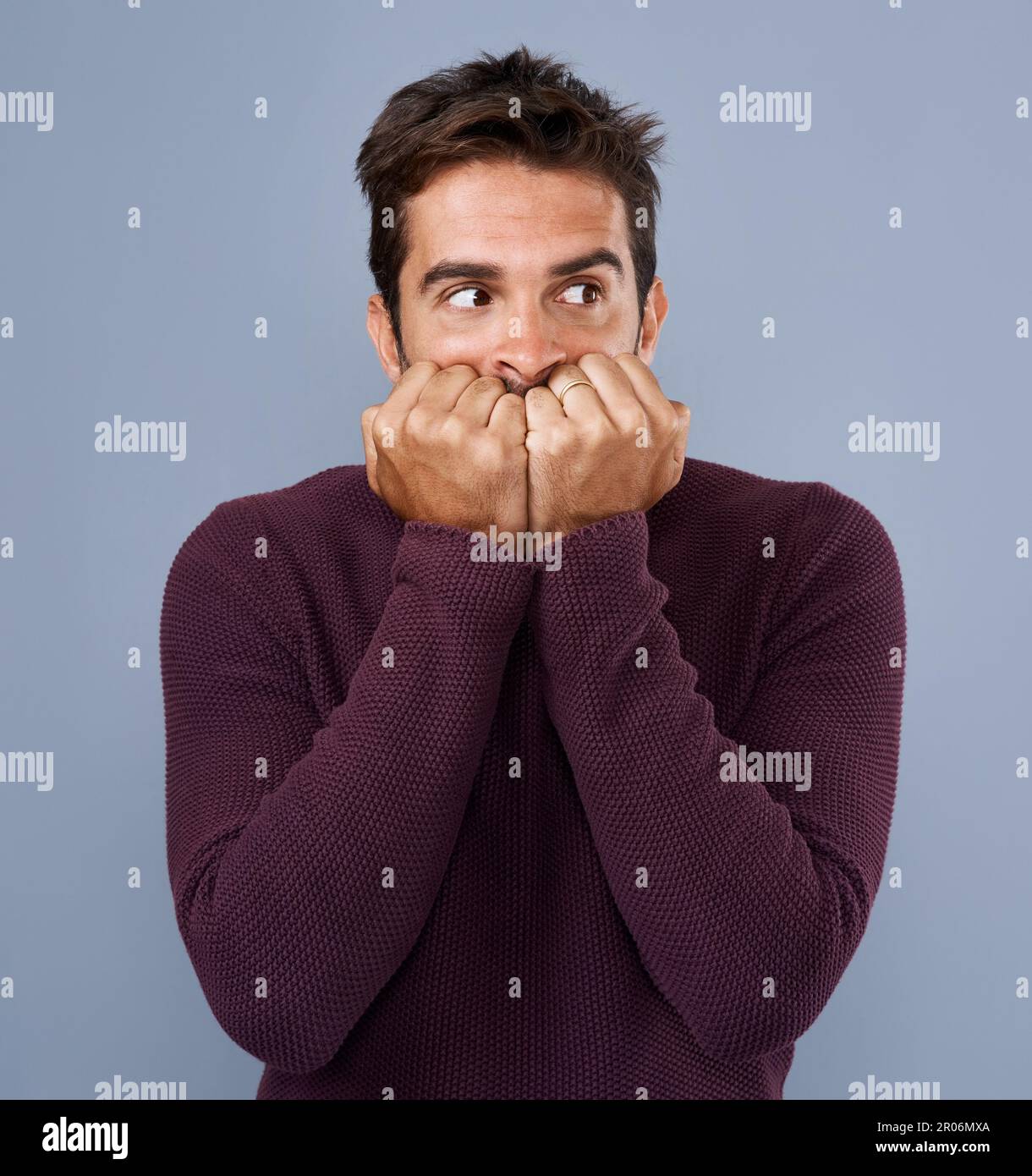 Its not safe here. Studio shot of a handsome young man looking scared ...