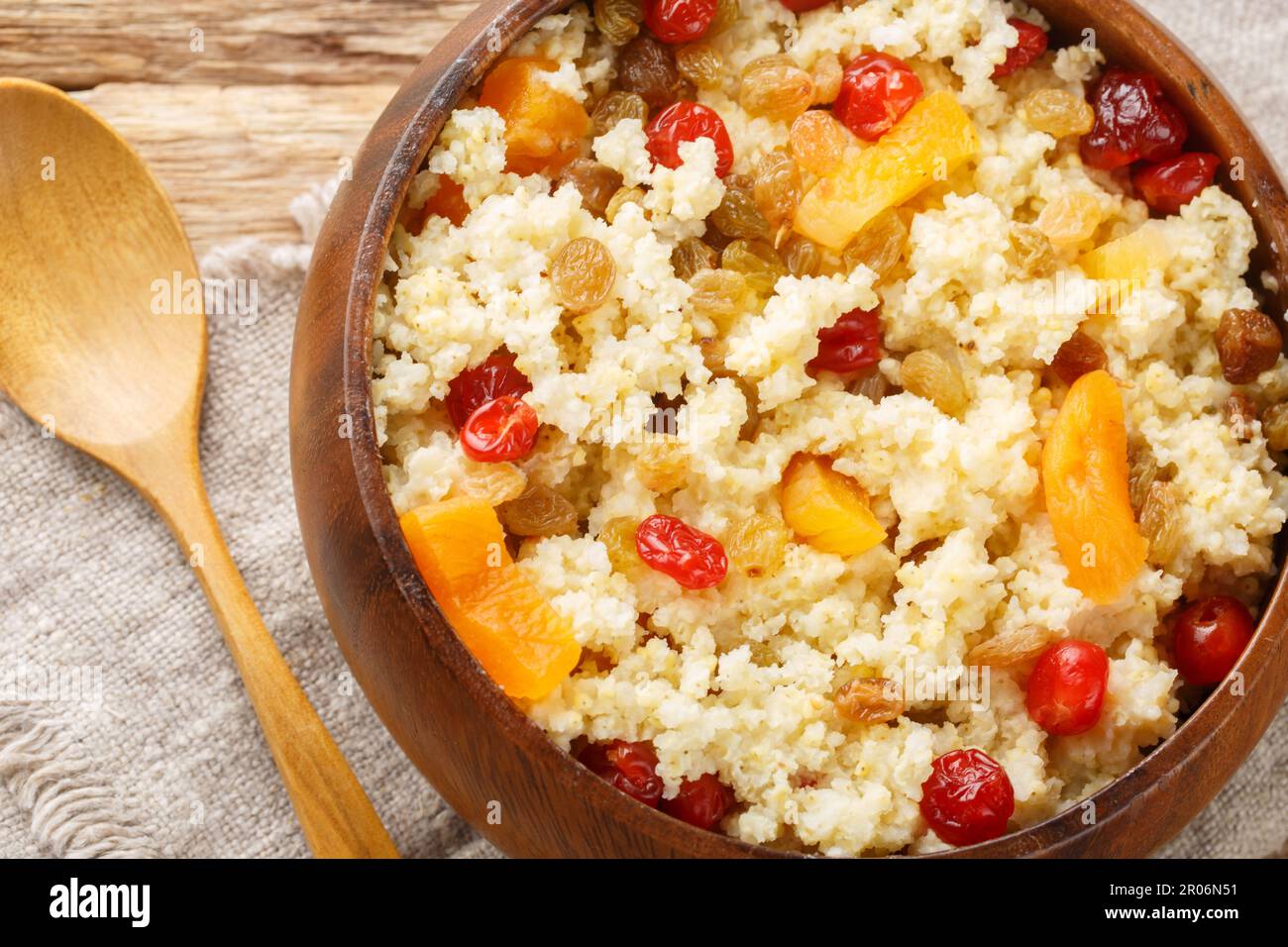 Millet with dried fruits and berry close-up in a bowl on the table ...